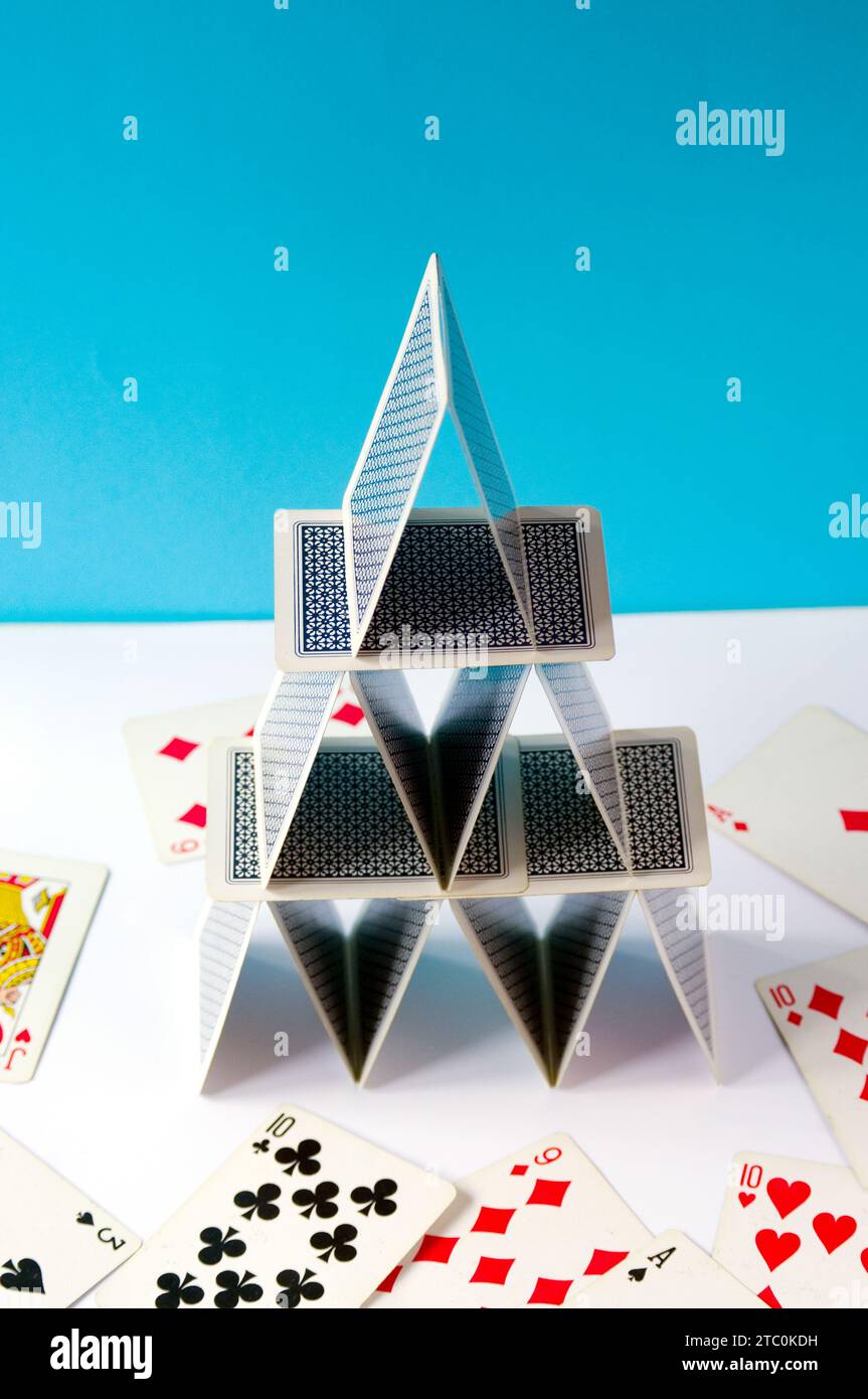 Playing card pyramid in balance, made with poker cards on a blue ...