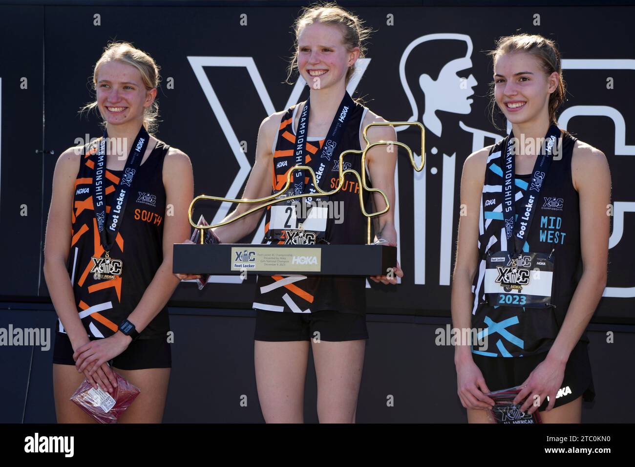 Elizabeth Leachman (center) poses with trophy after winning the girls ...