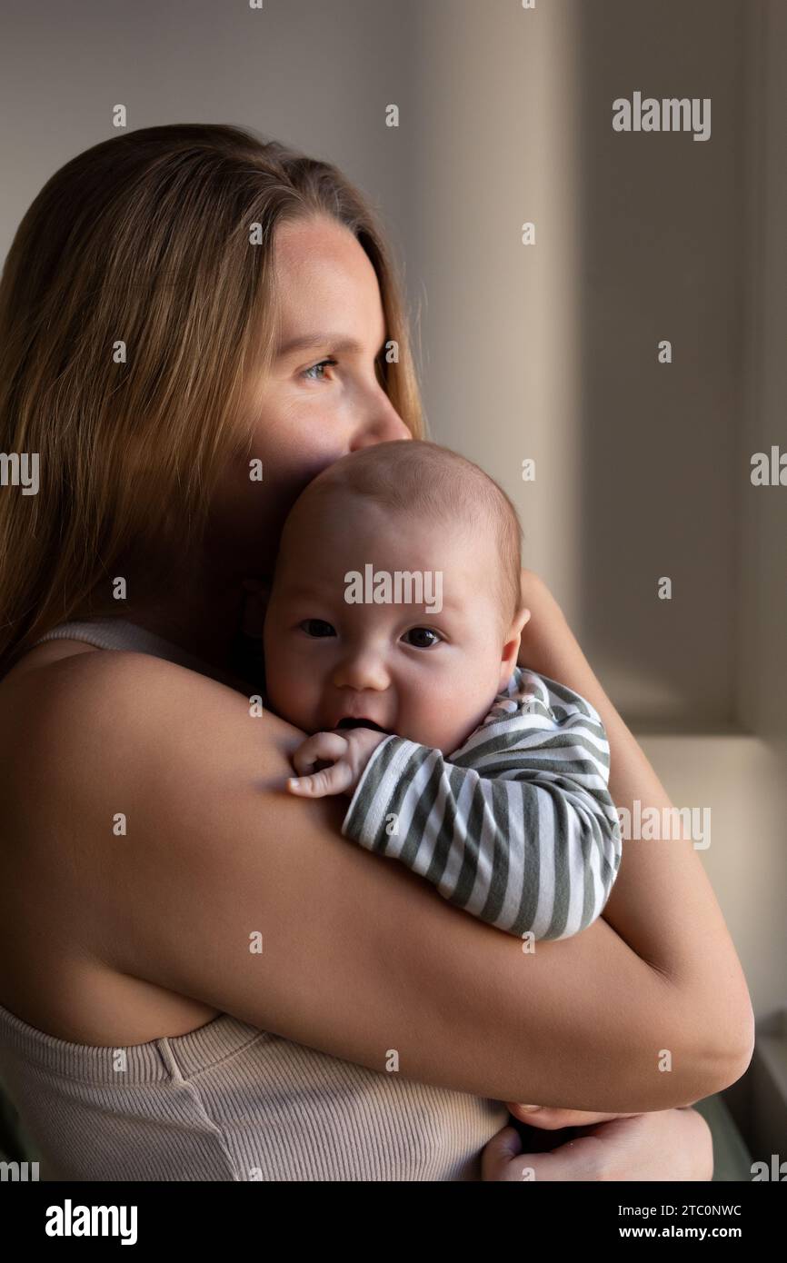 mother and newborn baby are lying on the bed in the bedroom opposite ...