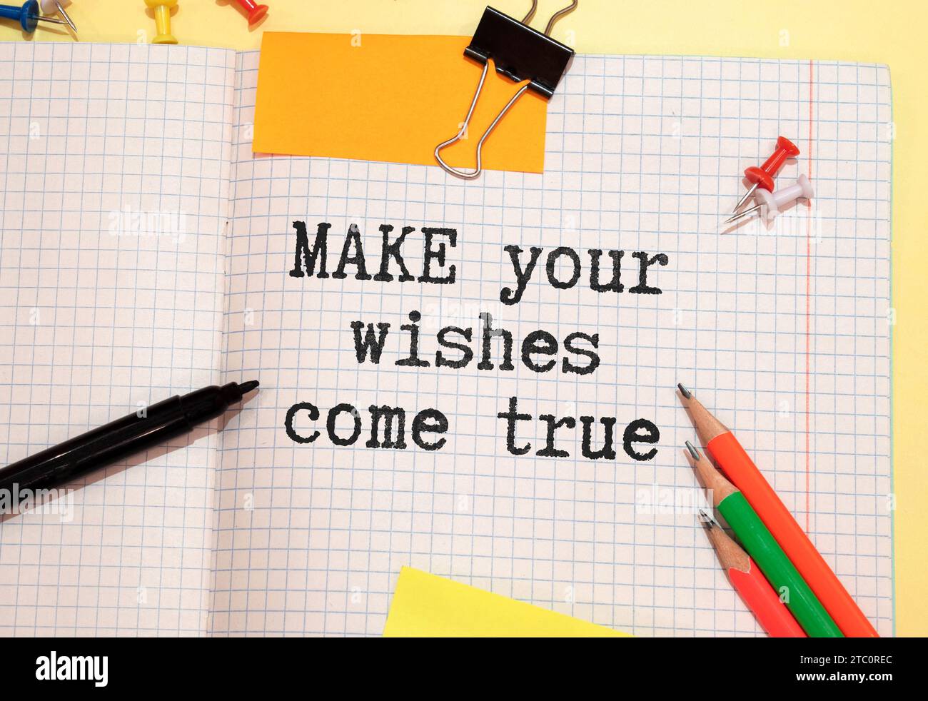 White notebook with inscription MAKE YOUR WISHES COME TRUE written in ...