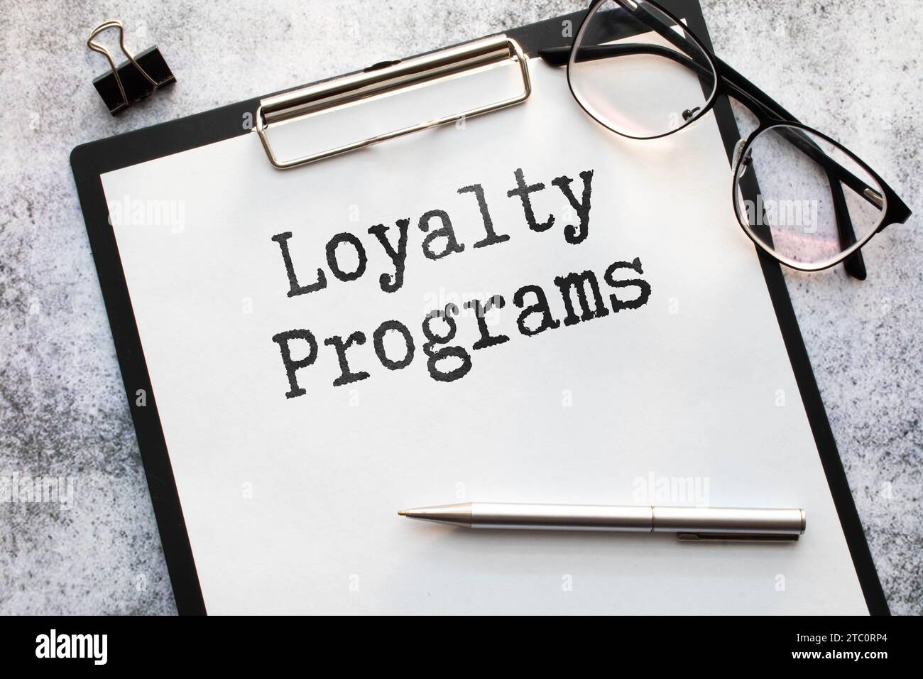 three notebooks and a page with text Loyalty Program Stock Photo - Alamy
