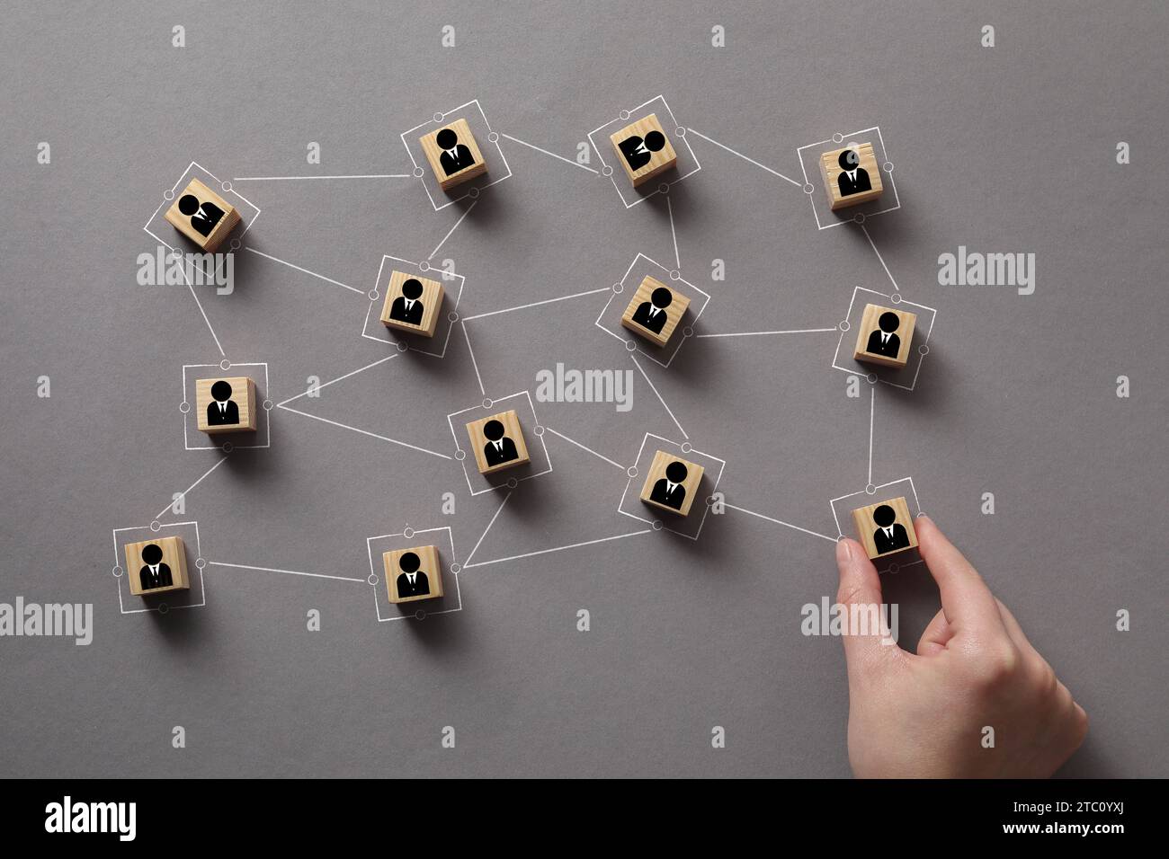 Teamwork. Woman arranging wooden cubes with human icons linked together ...