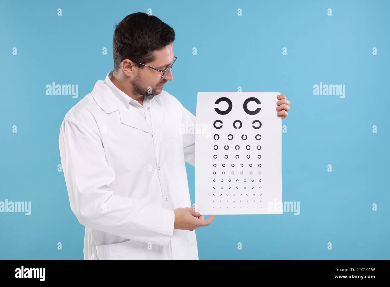 Ophthalmologist with vision test chart on light blue background Stock ...