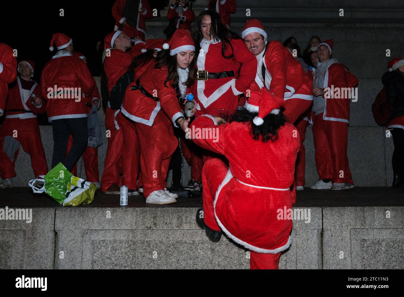 London, UK. 9th December, 2023. SantaCon revellers dressed in Father ...