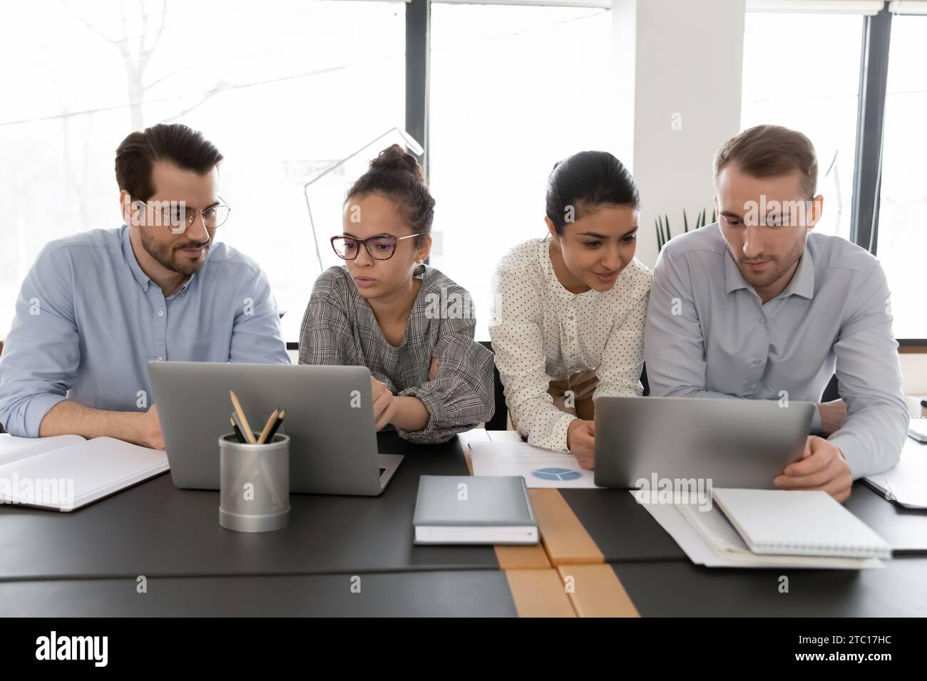 Multiracial colleagues use laptops at office training Stock Photo - Alamy