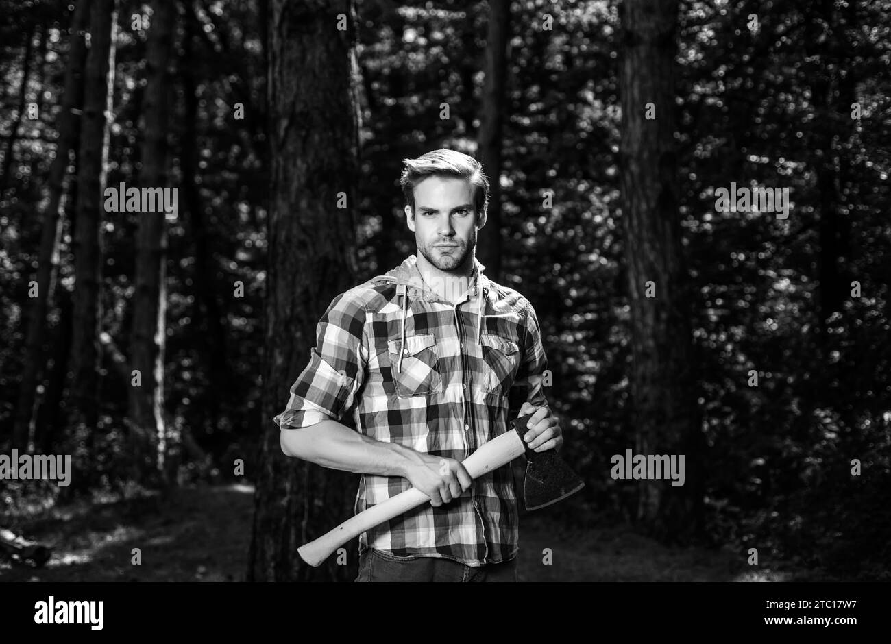 A handsome young man with a beard carries a tree. Stylish young man ...