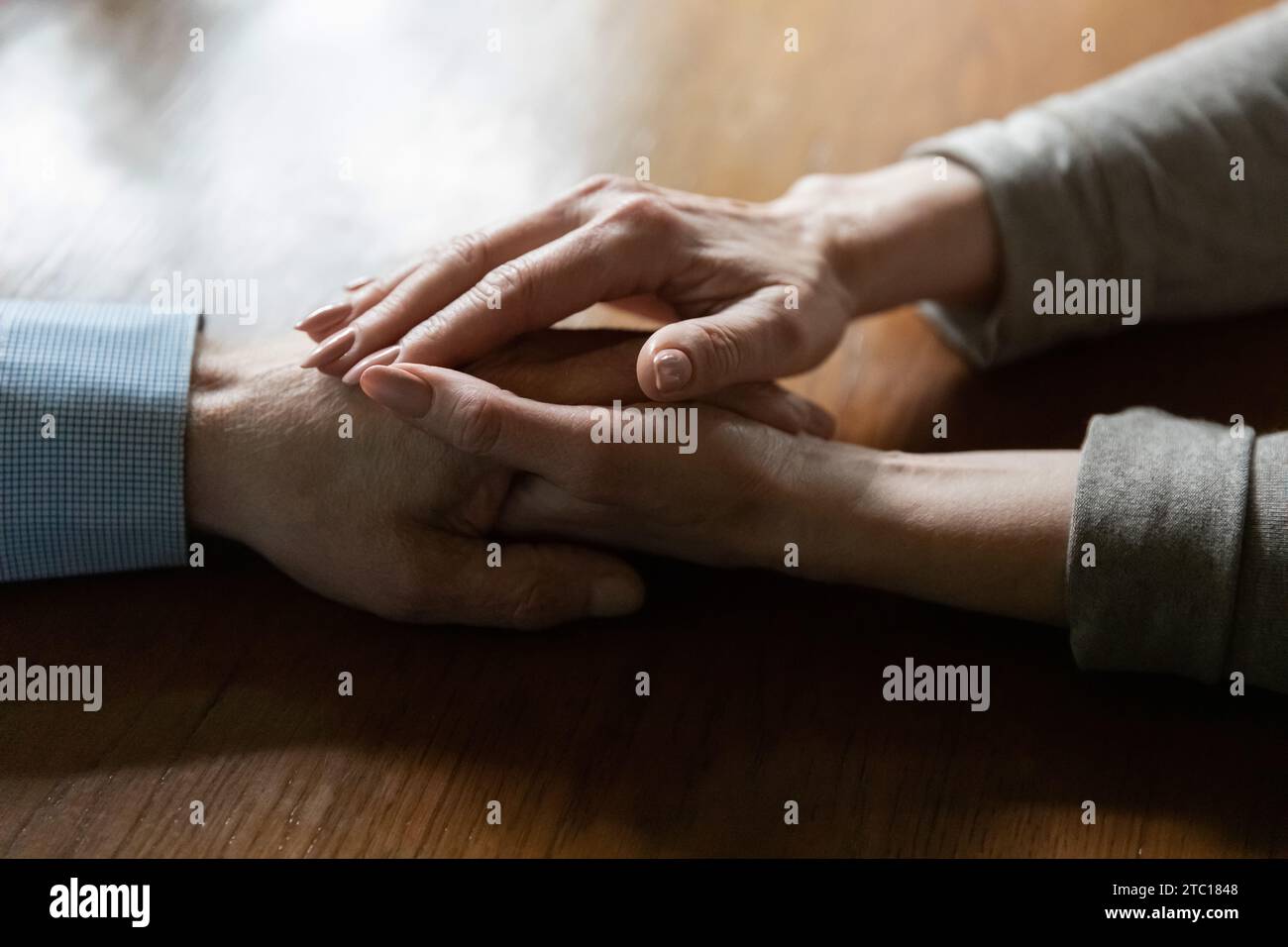 Affectionate middle aged woman touching mature man hand share hope ...