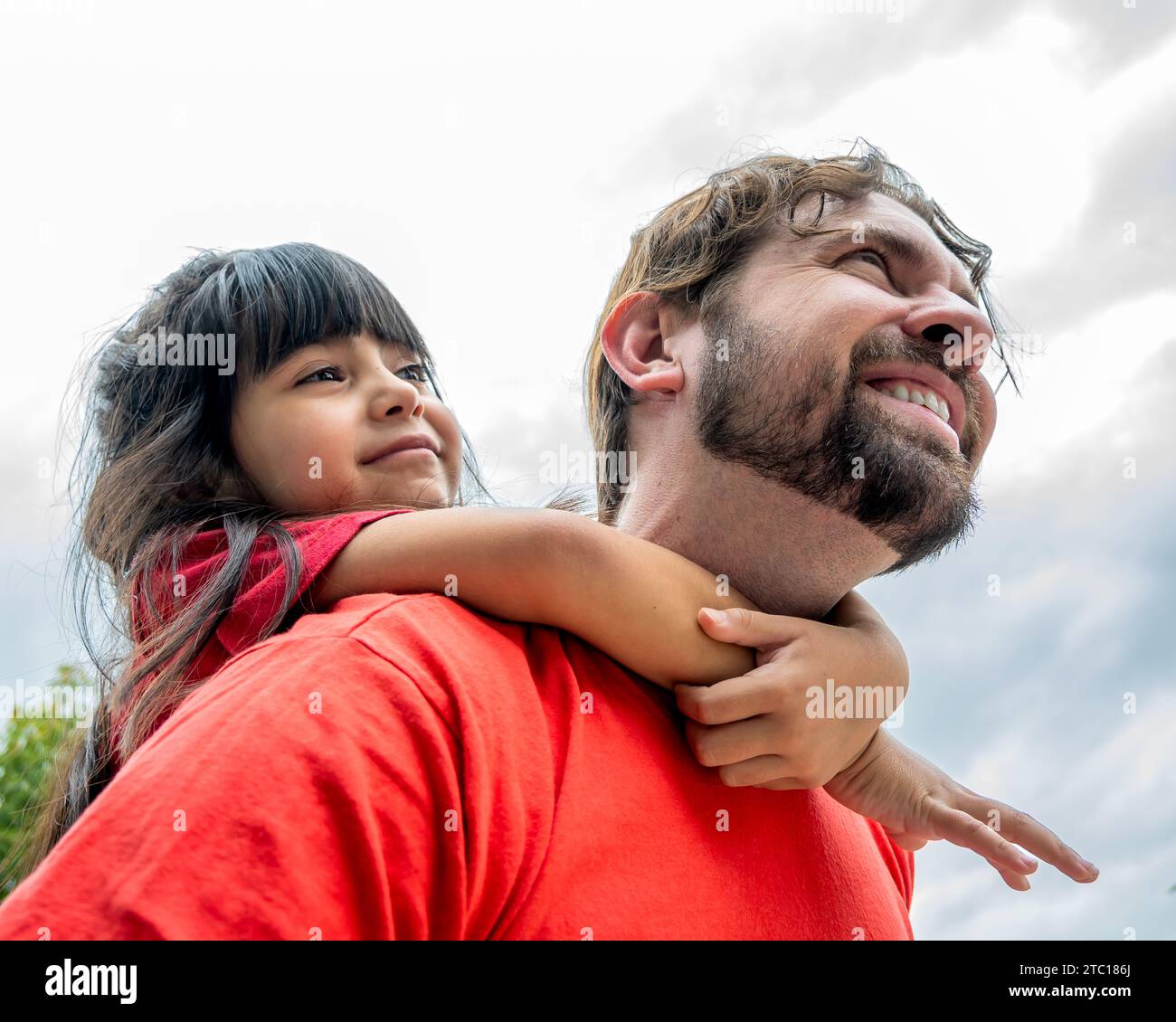 Low angle photo of a Latin father with his daughter hugging him from ...
