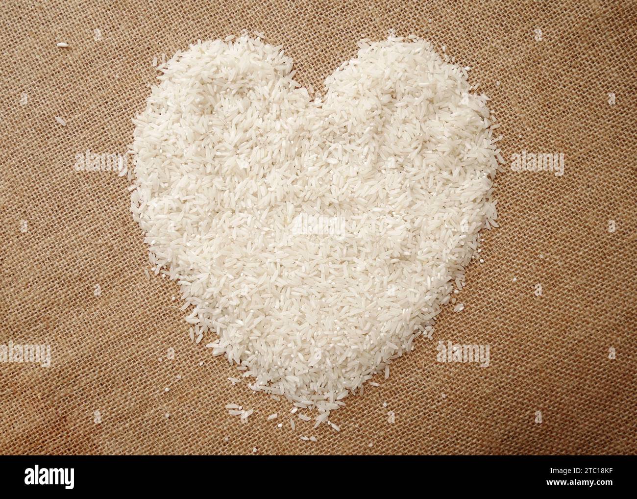 Organic white rice in heart shape Stock Photo - Alamy