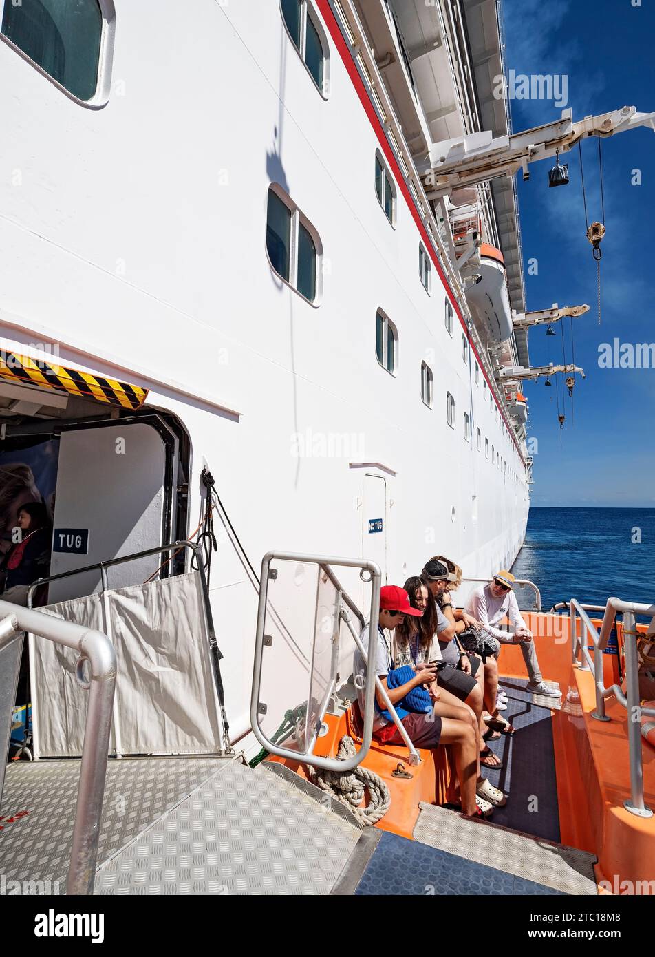 South Pacific Cruise / Cruise ship passengers board a tender boat from ...