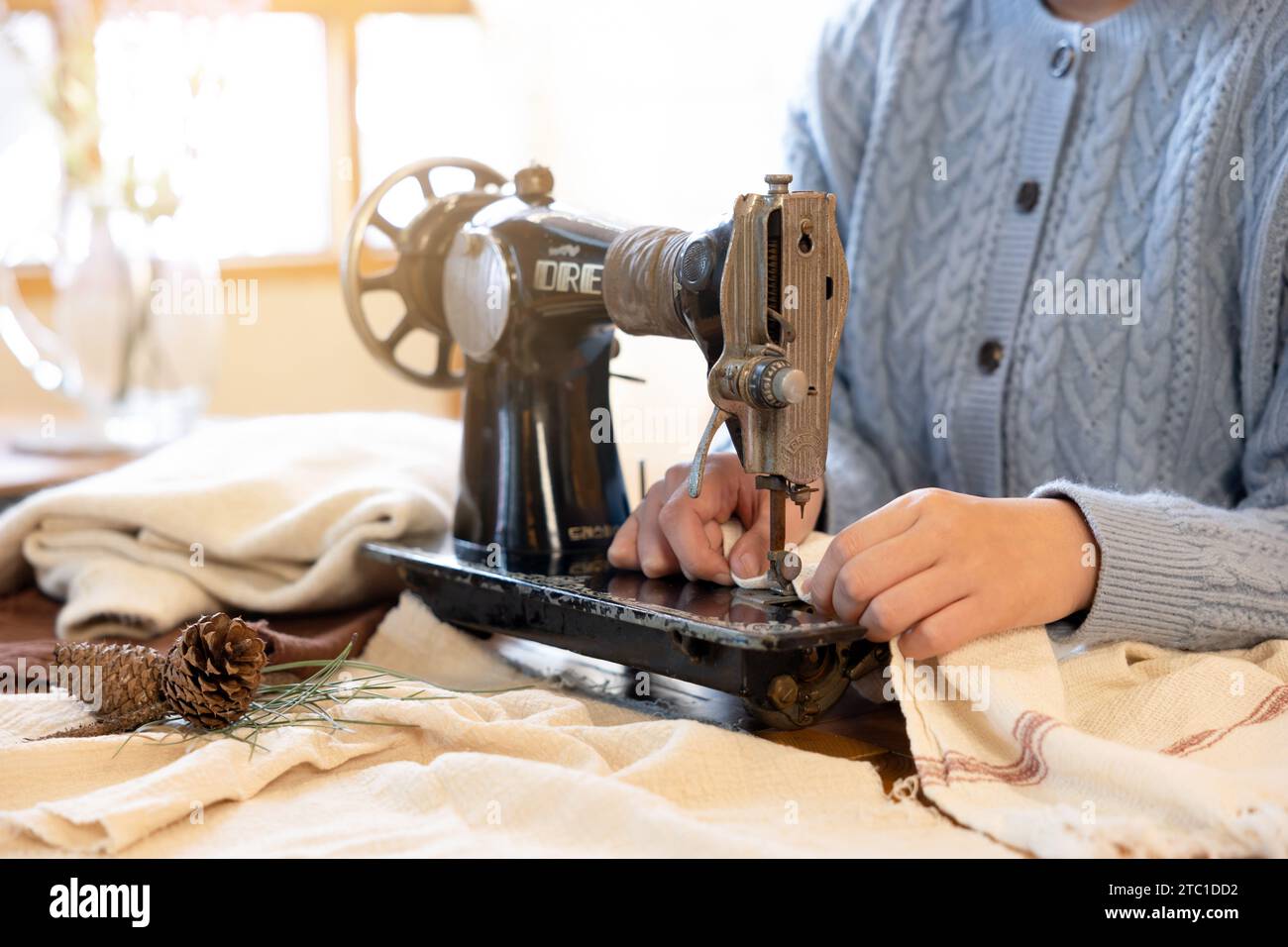 a woman works at a vintage sewing maching, nature light Stock Photo - Alamy
