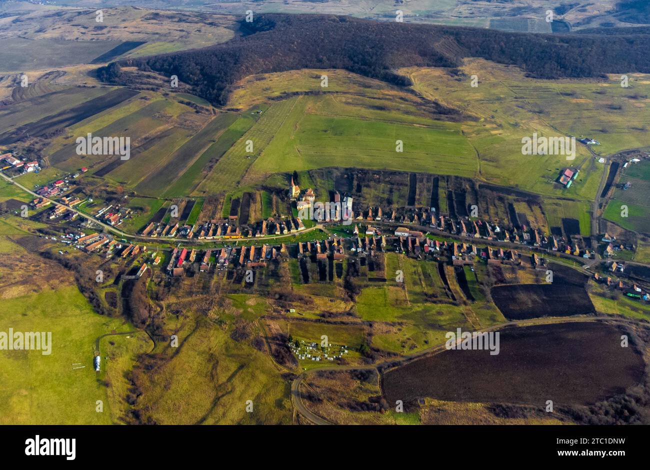 An aerial view of a picturesque village in Romania surrounded by lush ...