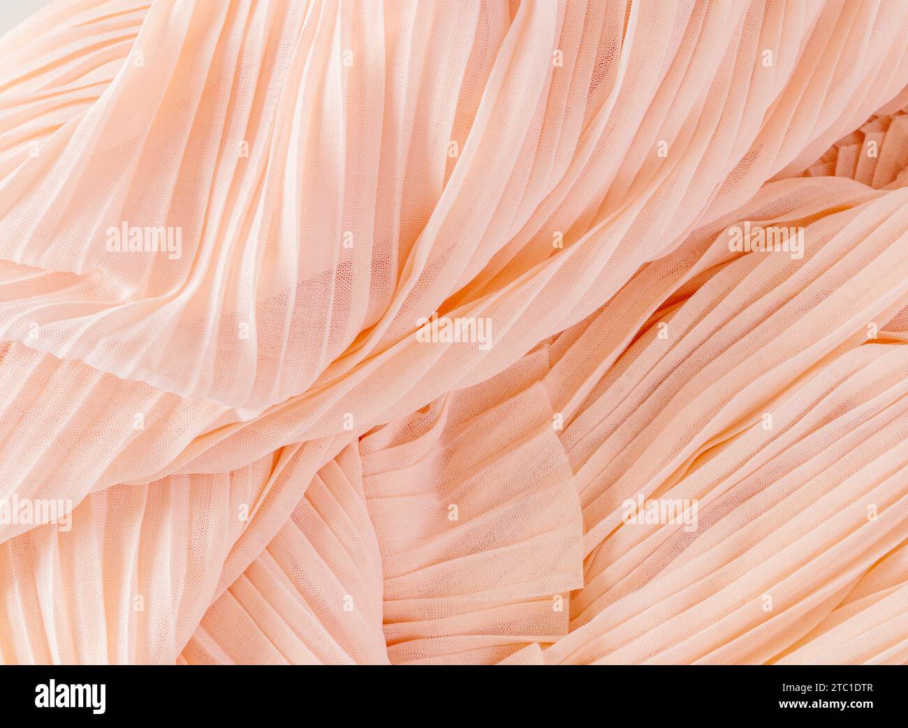 Luxurious chiffon factory fabric. Air waves of peach-colored folds ...
