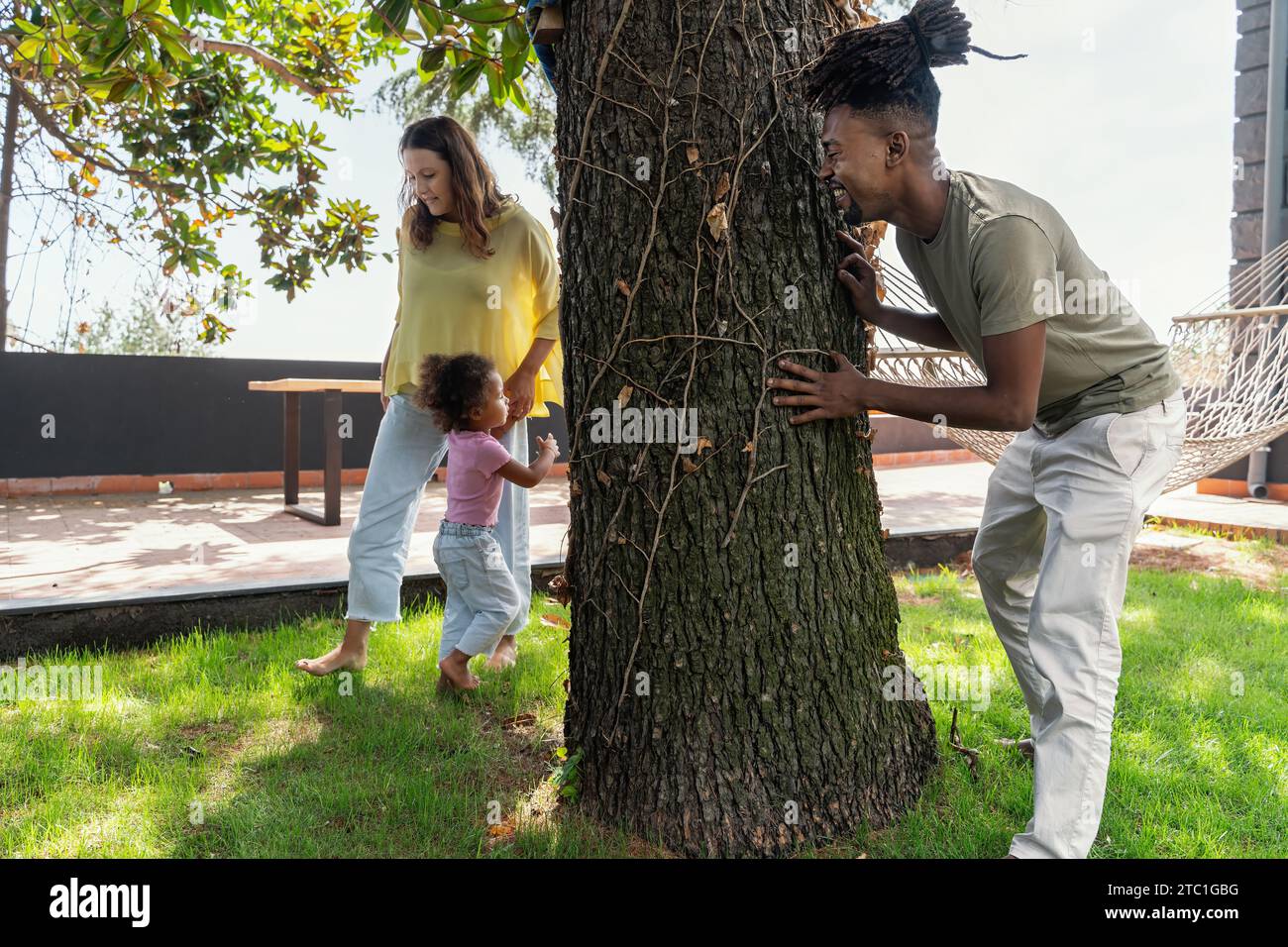 An interracial family engages in playful hide and seek, with a child's ...