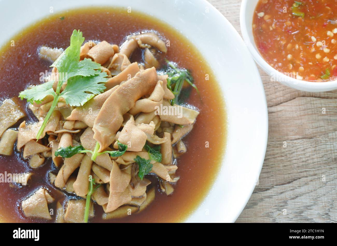 stewed duck intestine in brown soy soup on plate dipping spicy sauce ...