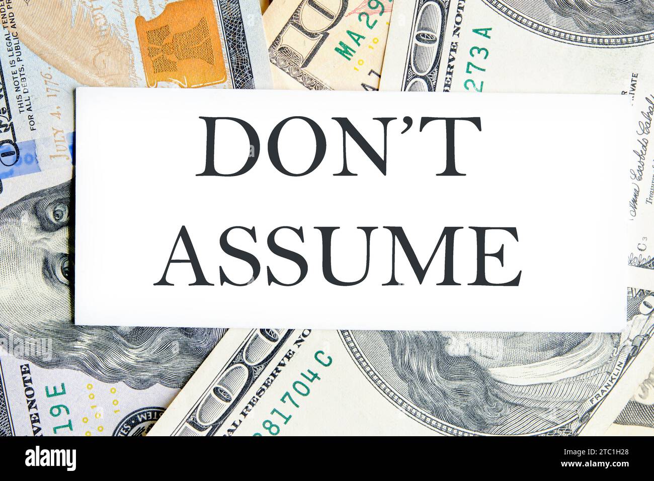 DO NOT ASSUME text, a word written on a white business card against a ...