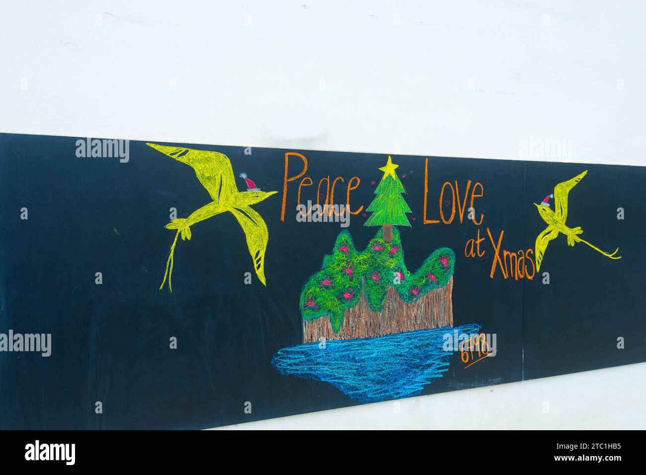 Peace and love Christmas message on a chalkboard in the streets of ...