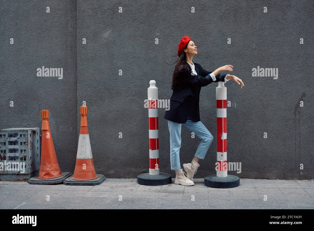 Fashion woman standing leaning against a wall street against a ...