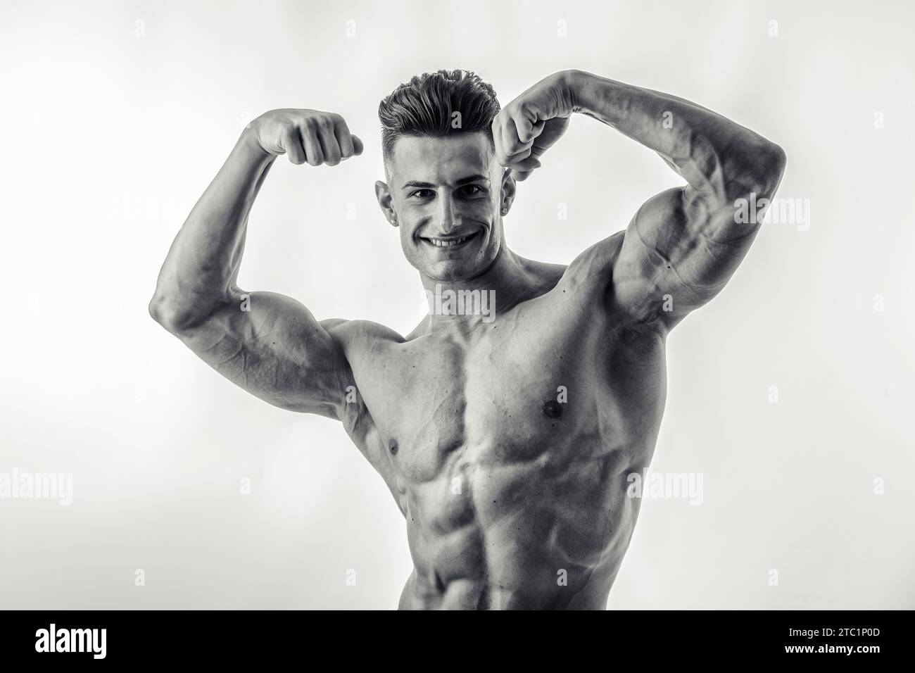 A bodybuilder man flexing his muscles in a black and white photo in ...