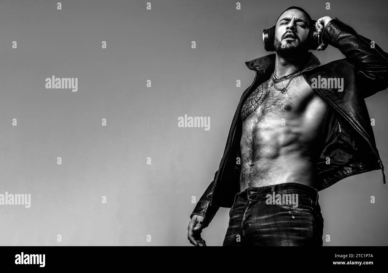 Music for Dj concept. Hot brutal man with a beard, a tattoo wearing ...