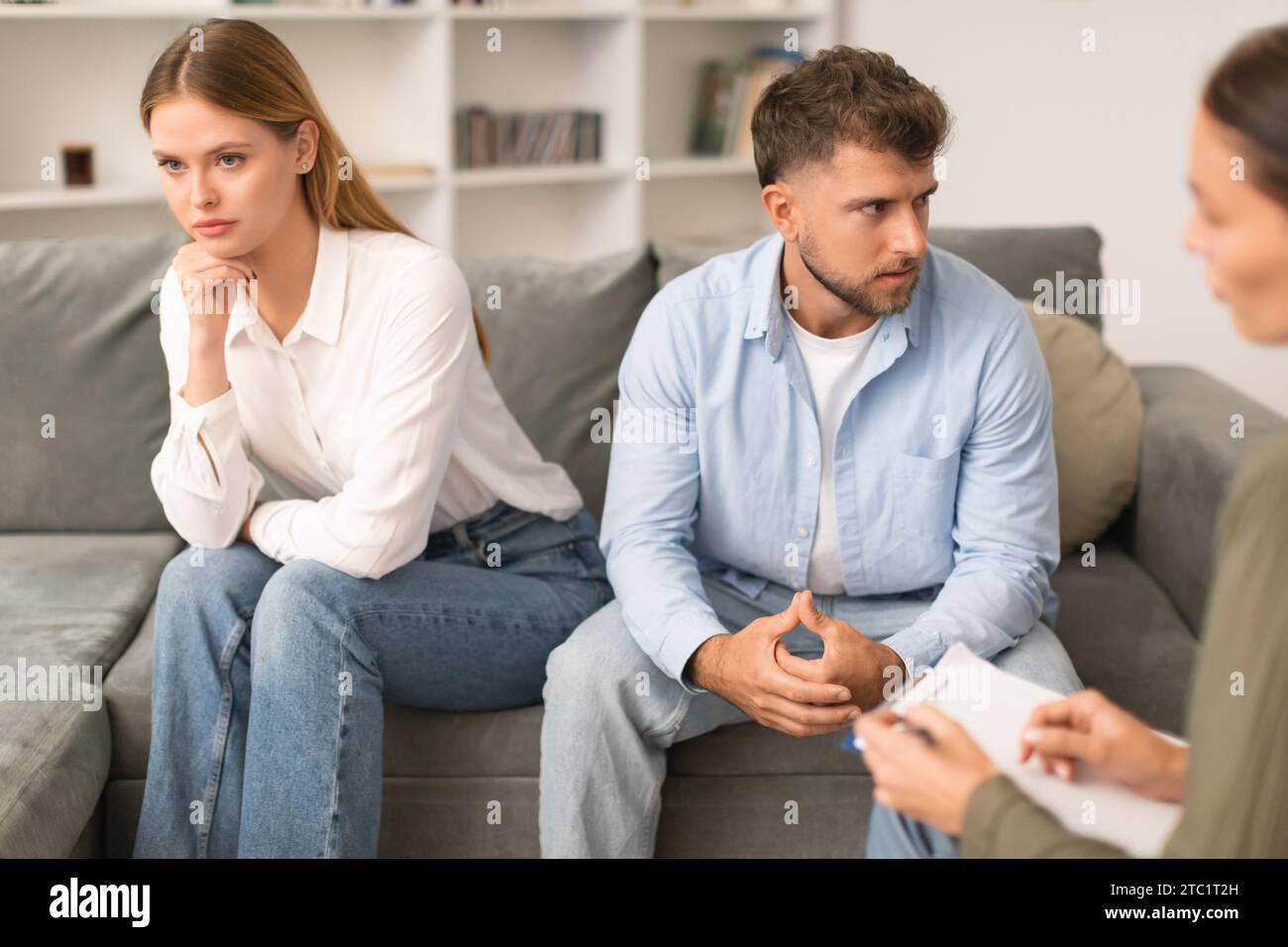Unhappy husband and wife sulking sitting in psychotherapist's office ...