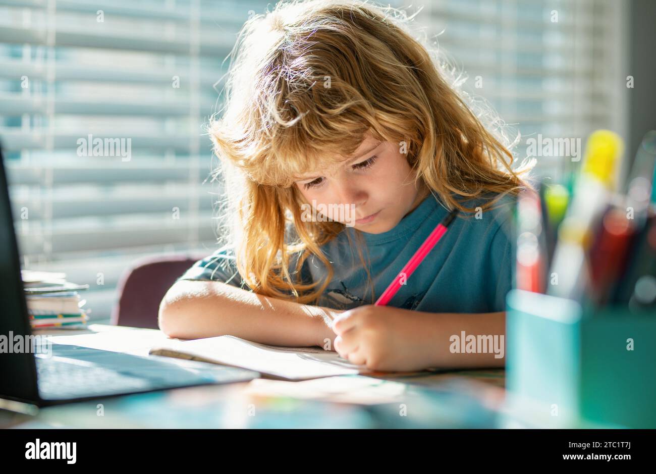 Child writing at school. Portrait of school kid boy siting on table ...