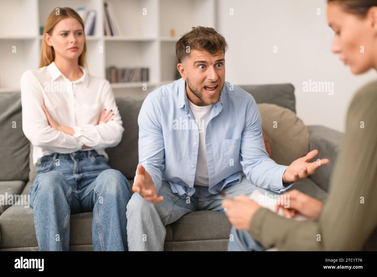 Aggressive husband shouts in anger during tense therapy session indoor ...