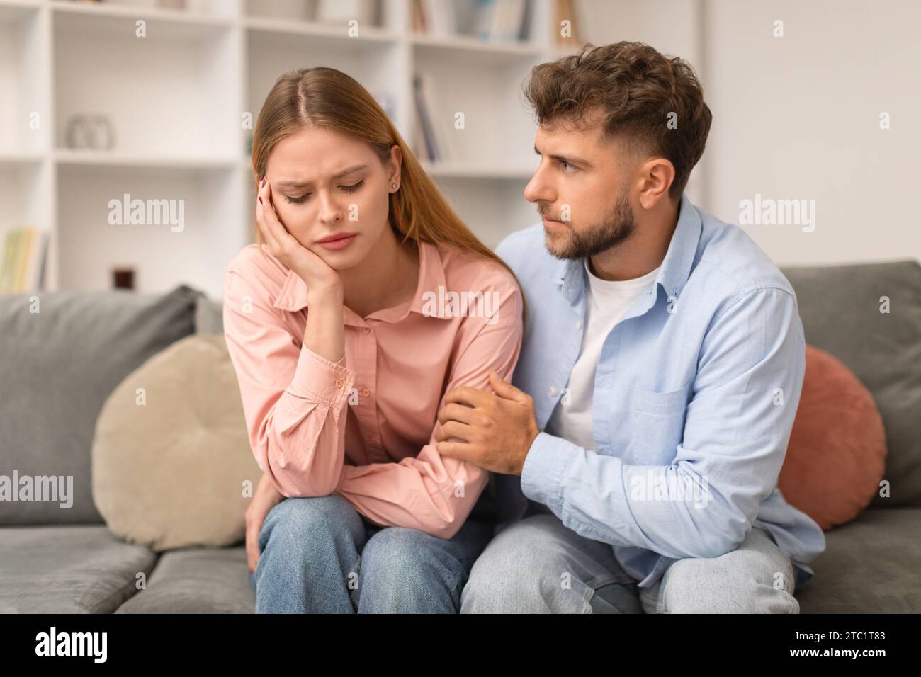 Husband Comforting Supporting Depressed Wife Sitting On Couch At Home ...
