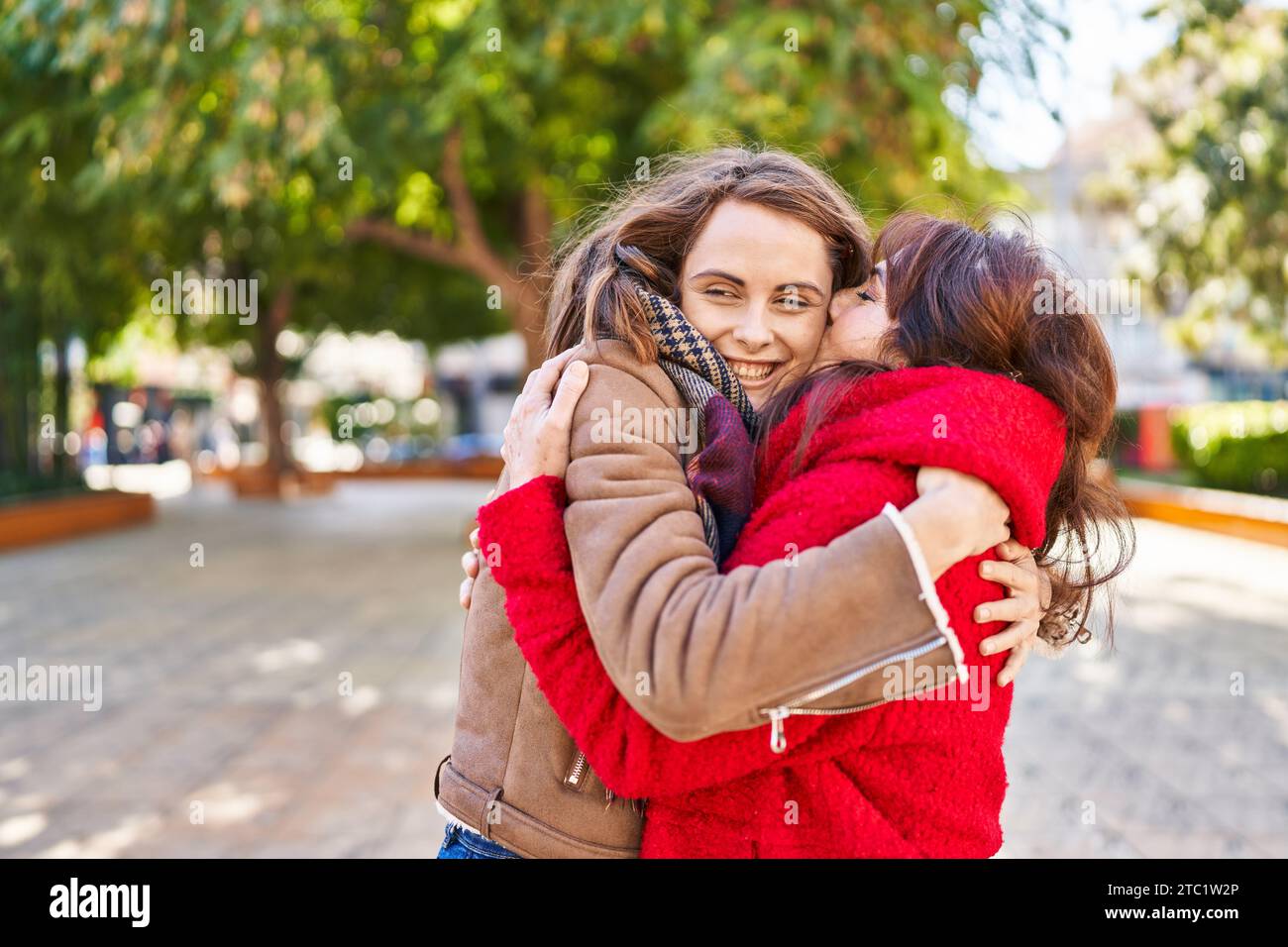 Two Women Mother And Daughter Hugging Each Other Kissing At Park Stock