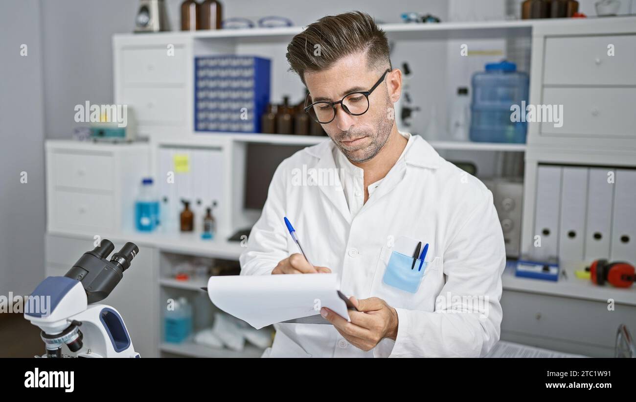 Handsome young hispanic man, charismatic scientist engrossed working ...