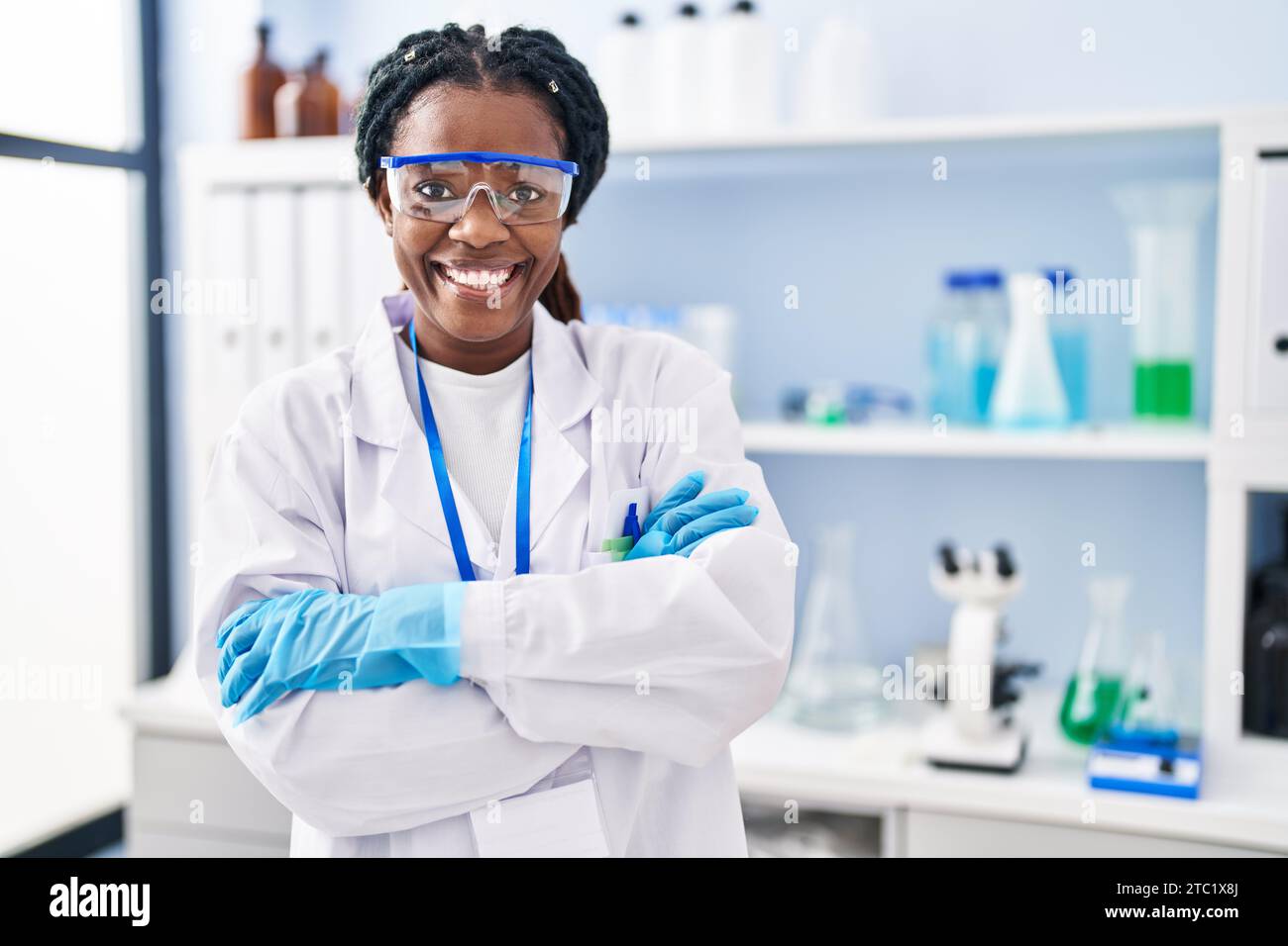 African american woman scientist smiling confident standing with arms crossed gesture at ...