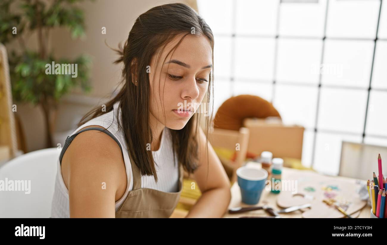 Serious-faced, attractive young hispanic woman artist, immersed in ...
