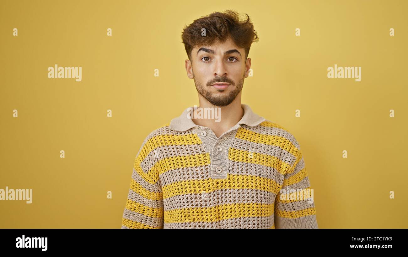 Stylish young arab man coolly bears his serious expression, standing ...