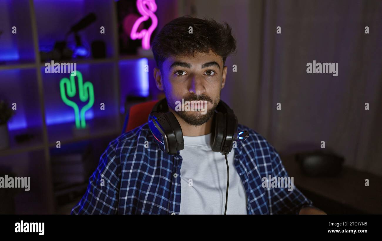 Focused in-game, young arab man, a serious-faced streamer, wearing ...
