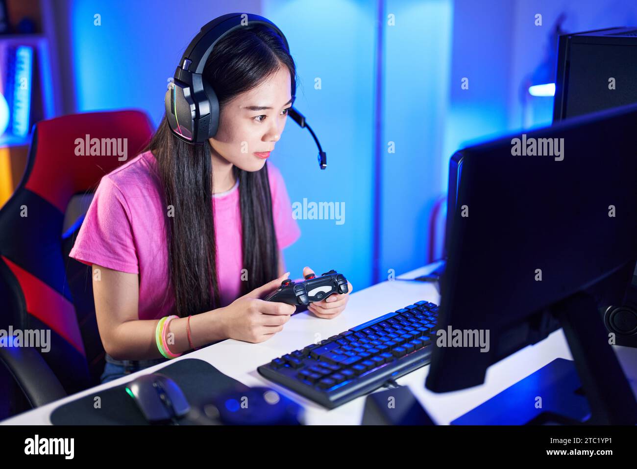Young chinese woman streamer playing video game using joystick at ...