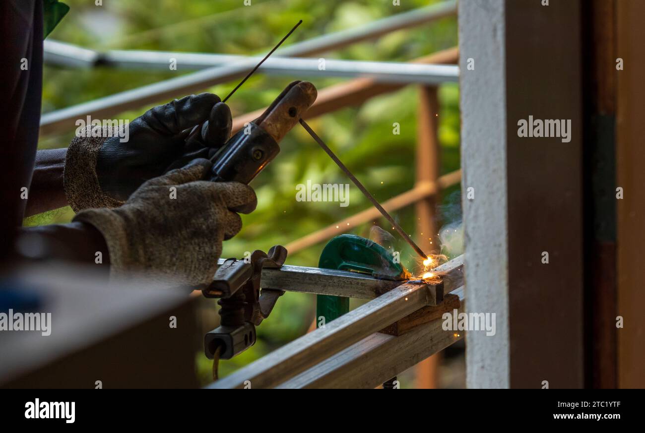 Red hot melted metal bead at the end of welding rod and welded metal ...