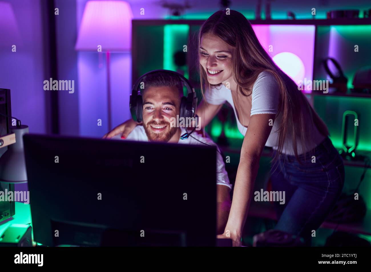 Young couple playing video games smiling with a happy and cool smile on ...