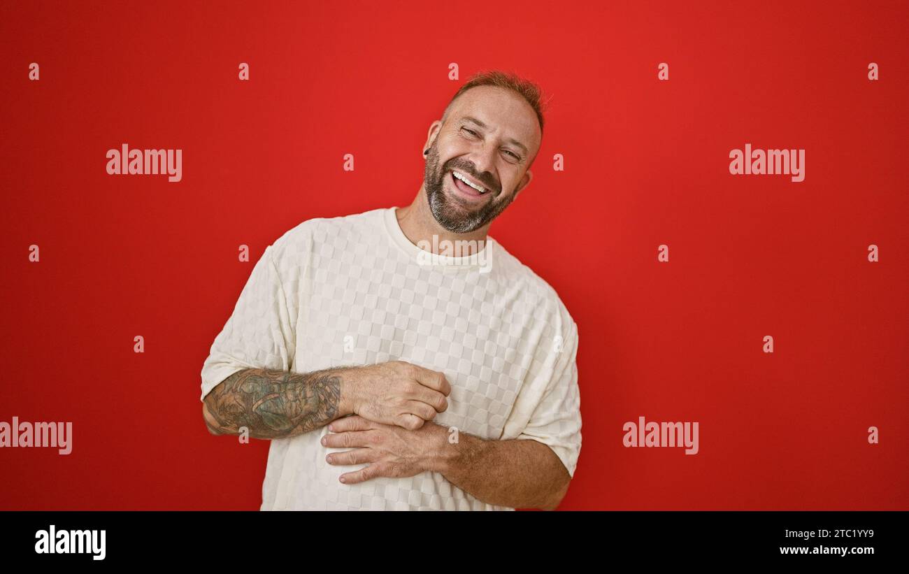 Happy-go-lucky young man caught in a burst of hearty laughter, standing ...