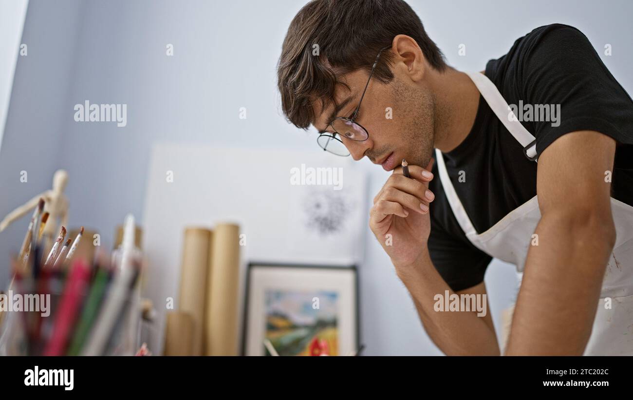 Young hispanice man, an engrossed artist, intensely thinking while ...
