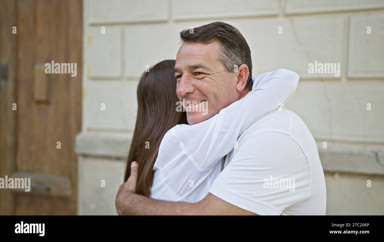 Confident father shares a hearty, smiling hug with his daughter on a ...