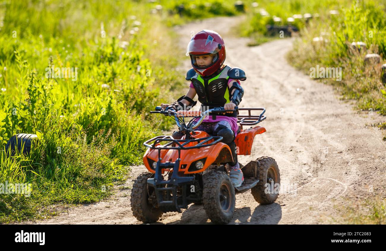 A child rides a quad bike through the mud. ATV rider rides Stock Photo ...