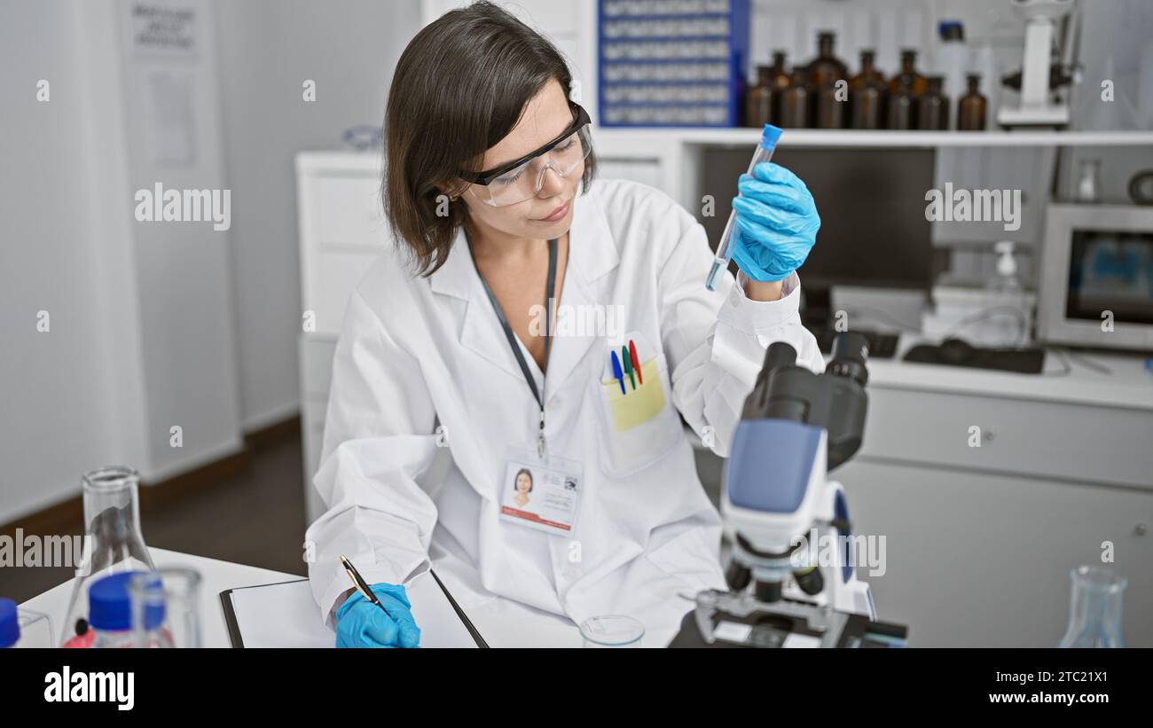 In her lab, a young, beautiful hispanic woman scientist works ...