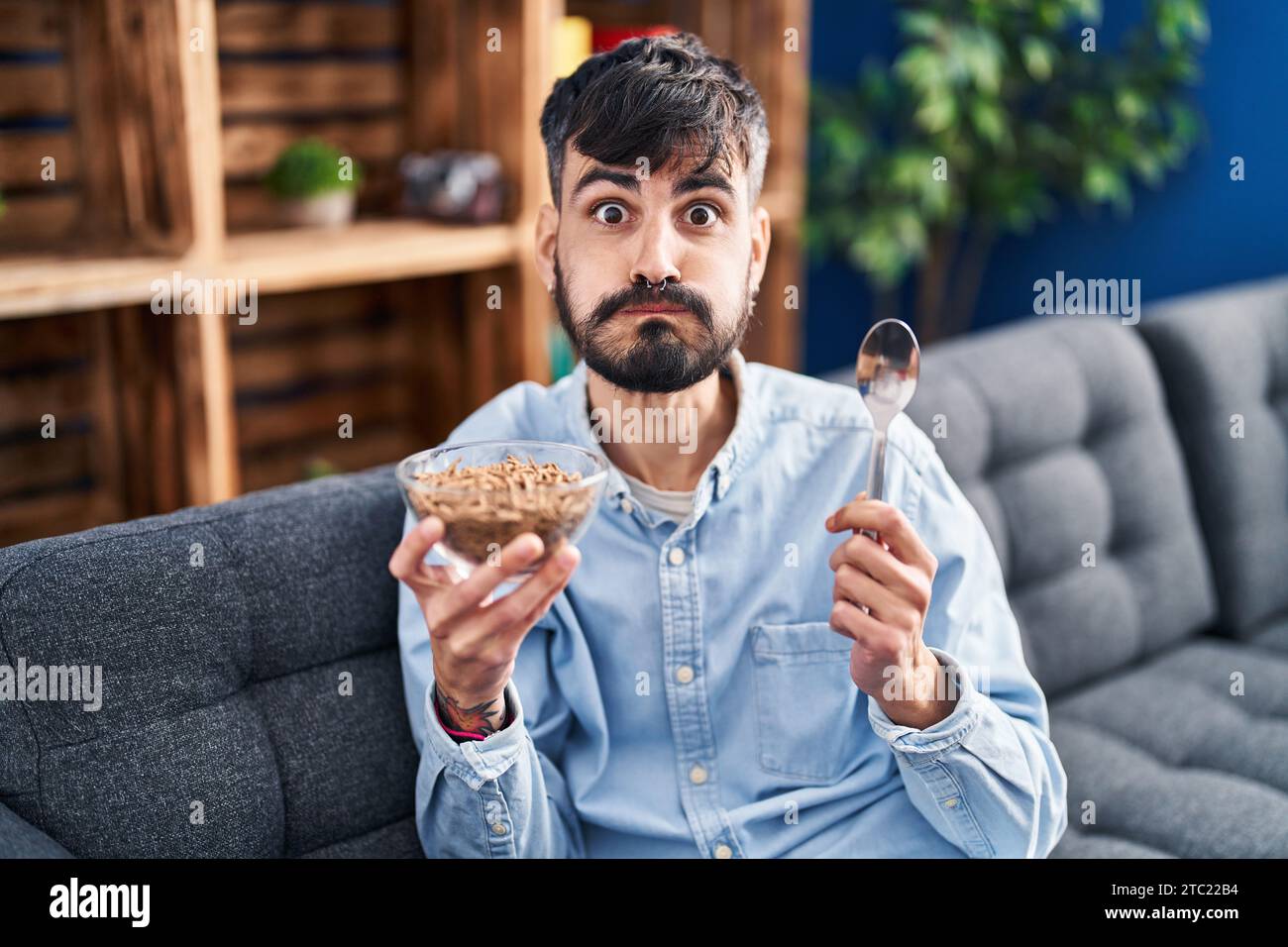 Young hispanic man with beard eating healthy whole grain cereals ...