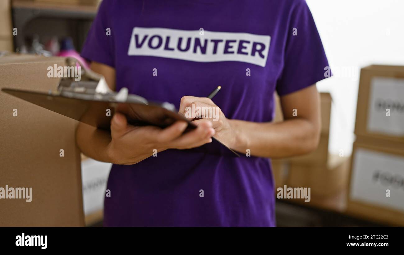 Hispanic woman volunteer's busy hands faithfully writing donations ...