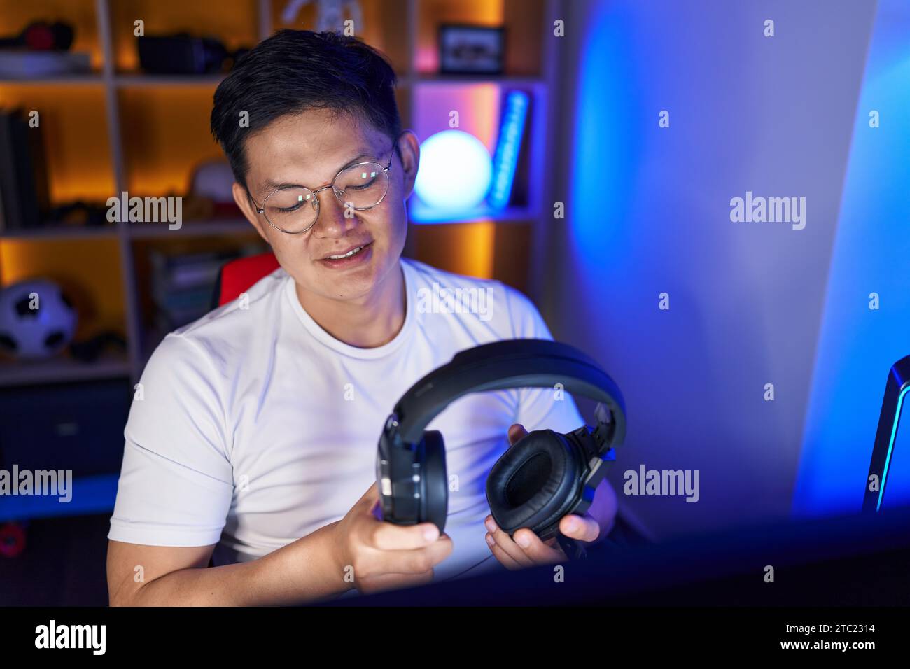 Young chinese man streamer smiling confident holding headphones at ...