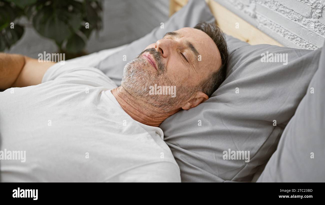 Exhausted, middle age man with grey hair, comfortably resting in the cozy comfort of his bedroom ...