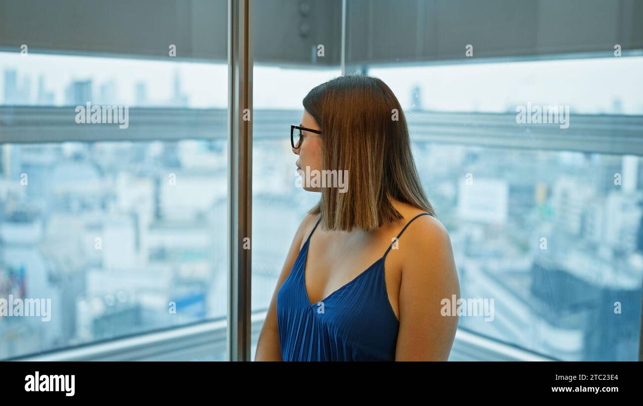 Elegant hispanic woman in glasses, admiring the city skyline from her ...