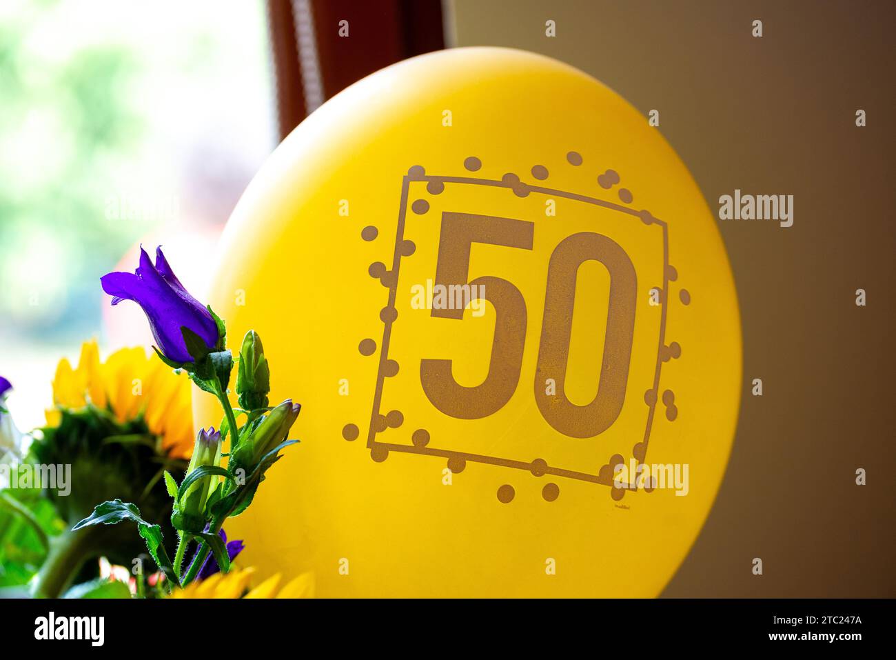 A balloon with a 50 printed on it for a 50th birthday with a bouquet of ...