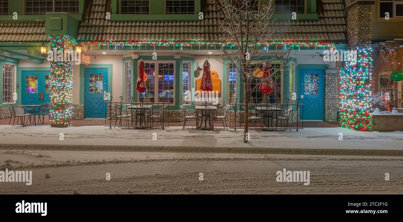 Night view of outdoor dining table with Christmas lights and snow at ...