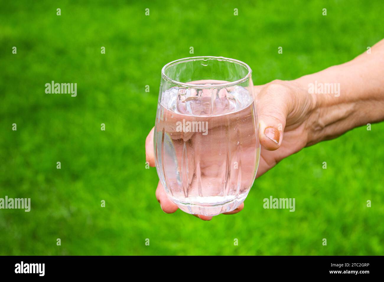 Grandmother giving a glass of clean water to a child. Selective focus ...